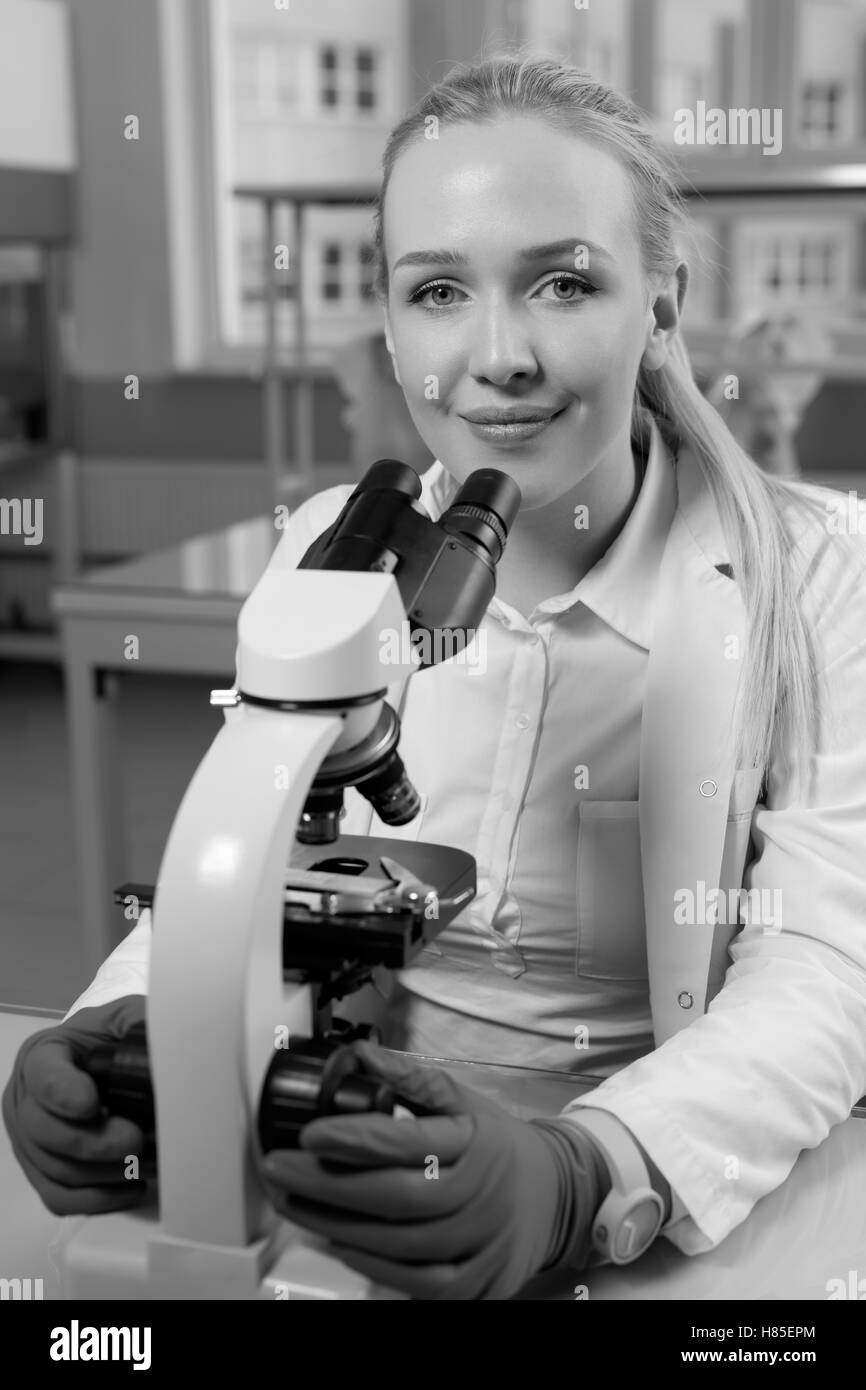 Female researcher using her microscope in a laboratory Stock Photo - Alamy