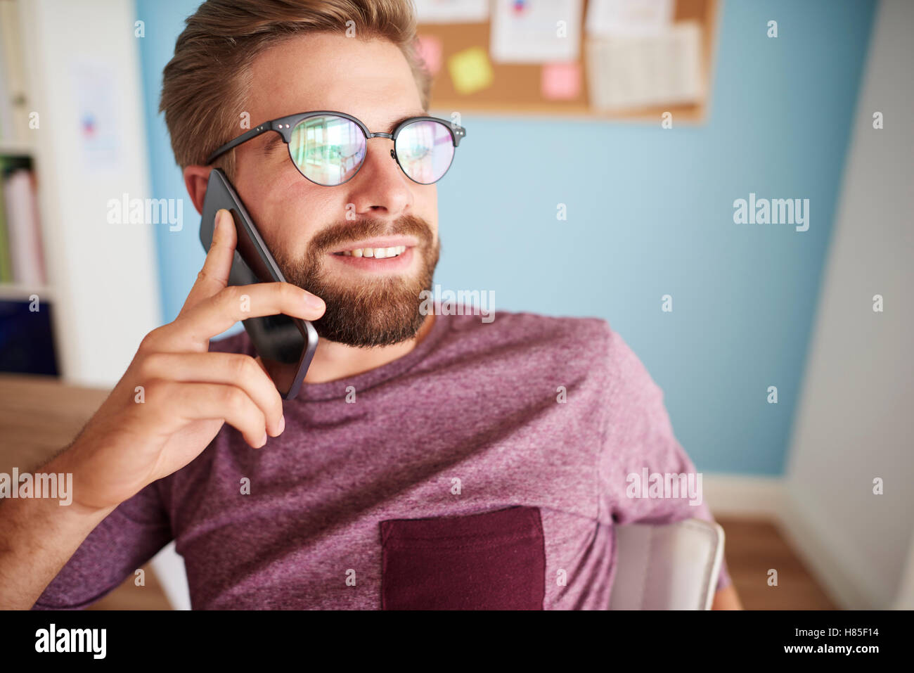 Sitting on chair and talking on the phone Stock Photo - Alamy