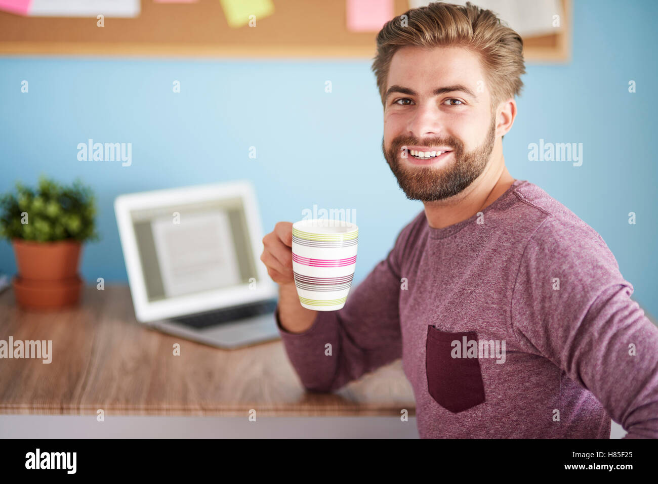 Drinking coffee and working on the laptop Stock Photo - Alamy
