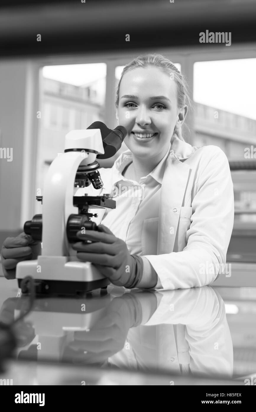 Female researcher using her microscope in a laboratory Stock Photo - Alamy