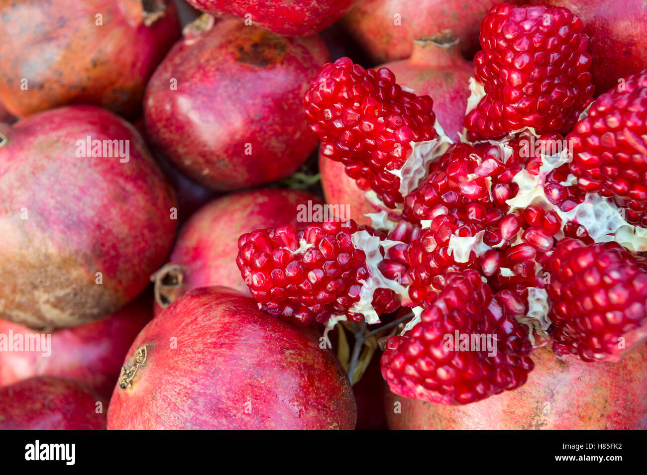 Fresh pomegranate split open to reveal the seeds on display at a ...