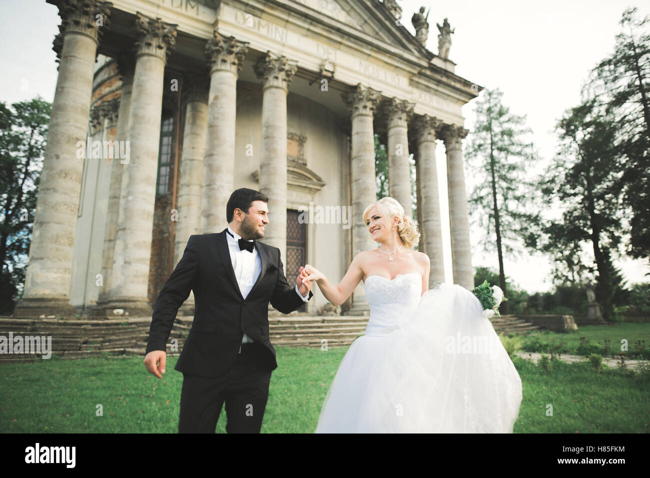 Beautiful romantic wedding couple of newlyweds hugging near old castle ... Beautiful romantic wedding couple of newlyweds hugging near old castle ...