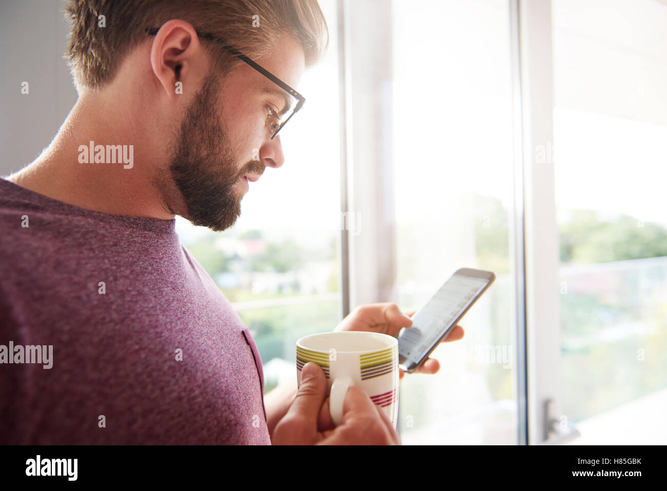 Man home morning checking phone hi-res stock photography and images - Alamy