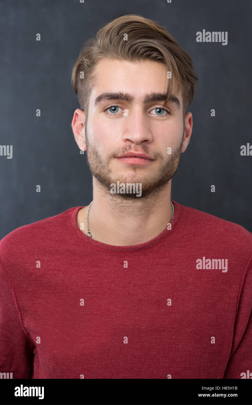 Young man in studio looking at camera Stock Photo - Alamy