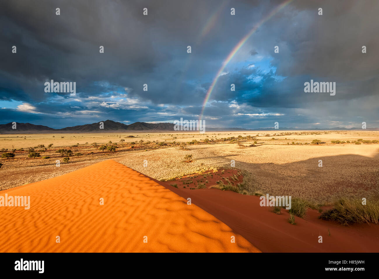 Storm with rainbows over sand dunes, Namibia Stock Photo - Alamy