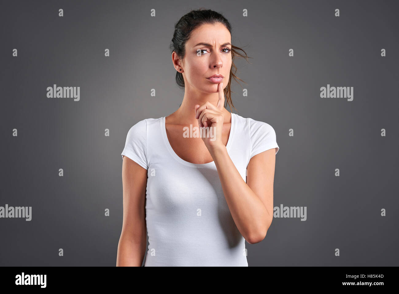 A beautiful young woman feeling and looking suspiciously Stock Photo ...