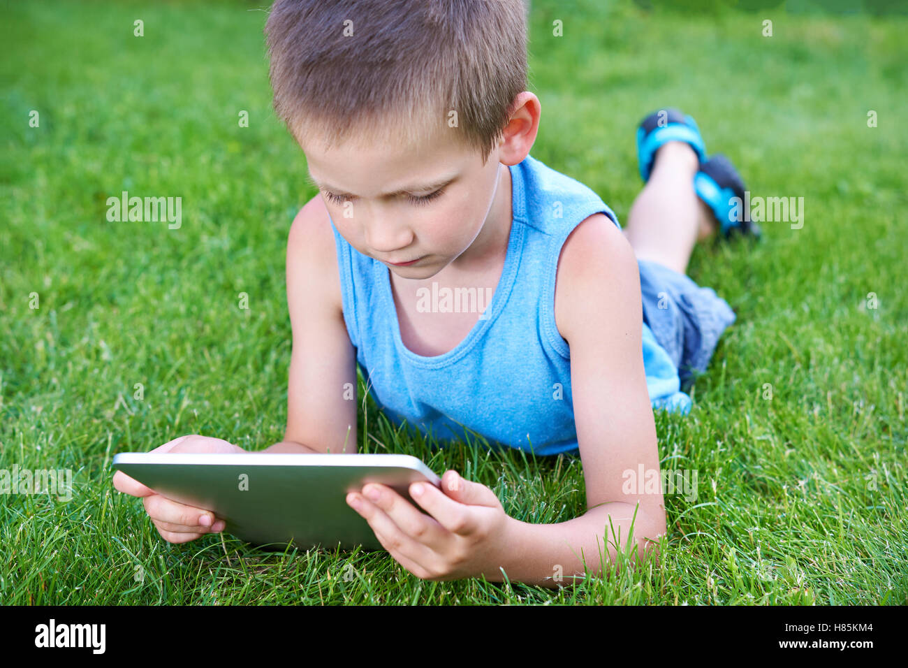Little boy with tablet pc in summer day Stock Photo - Alamy