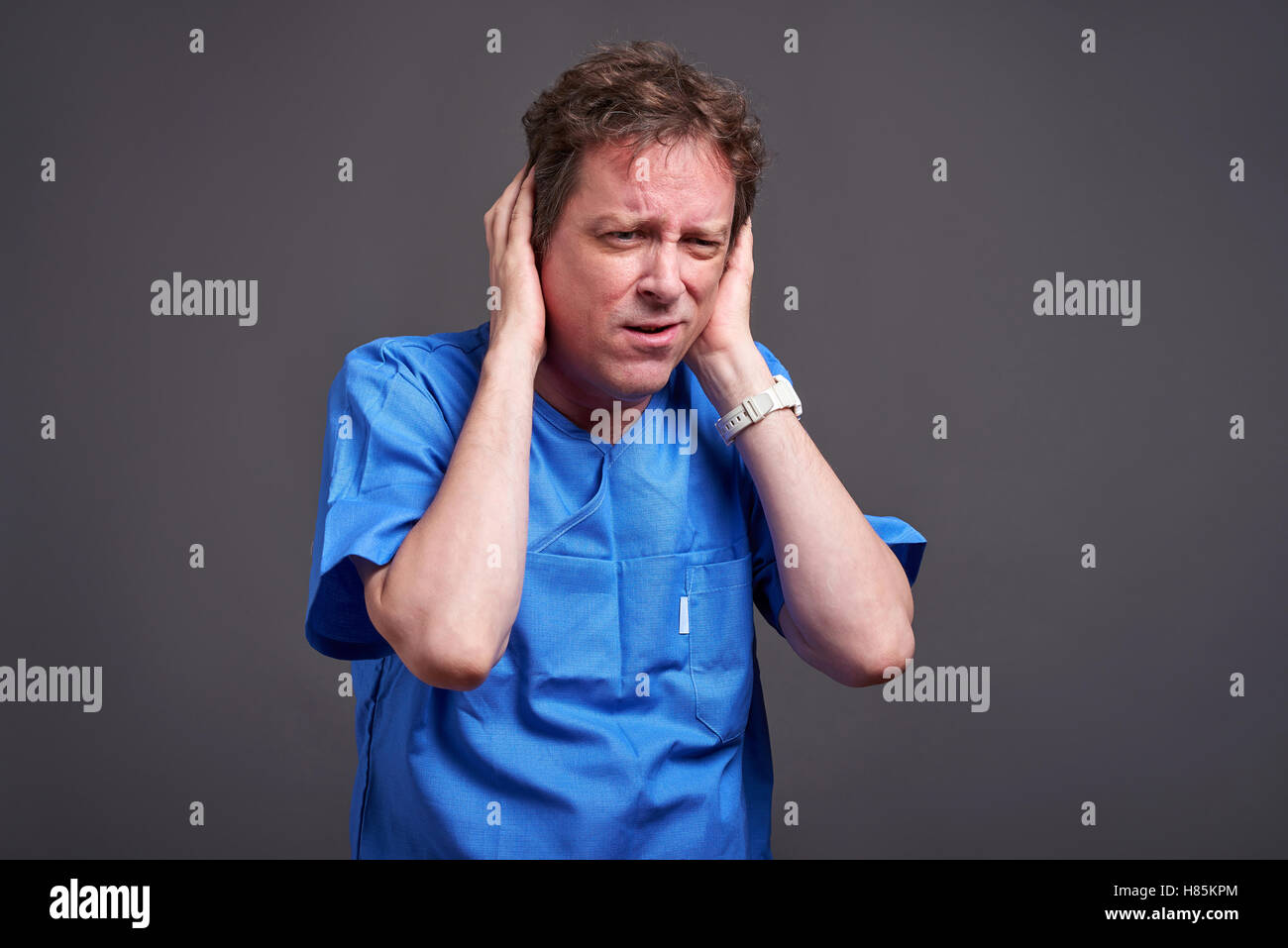 A middle aged male doctor standing and feeling scared Stock Photo - Alamy