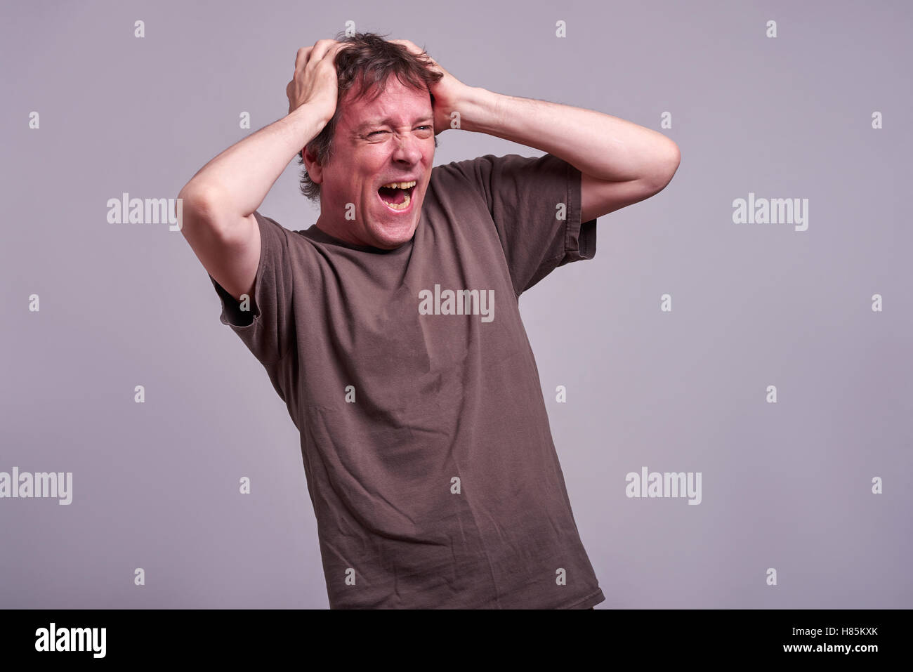 A middle aged man standing and screaming Stock Photo - Alamy