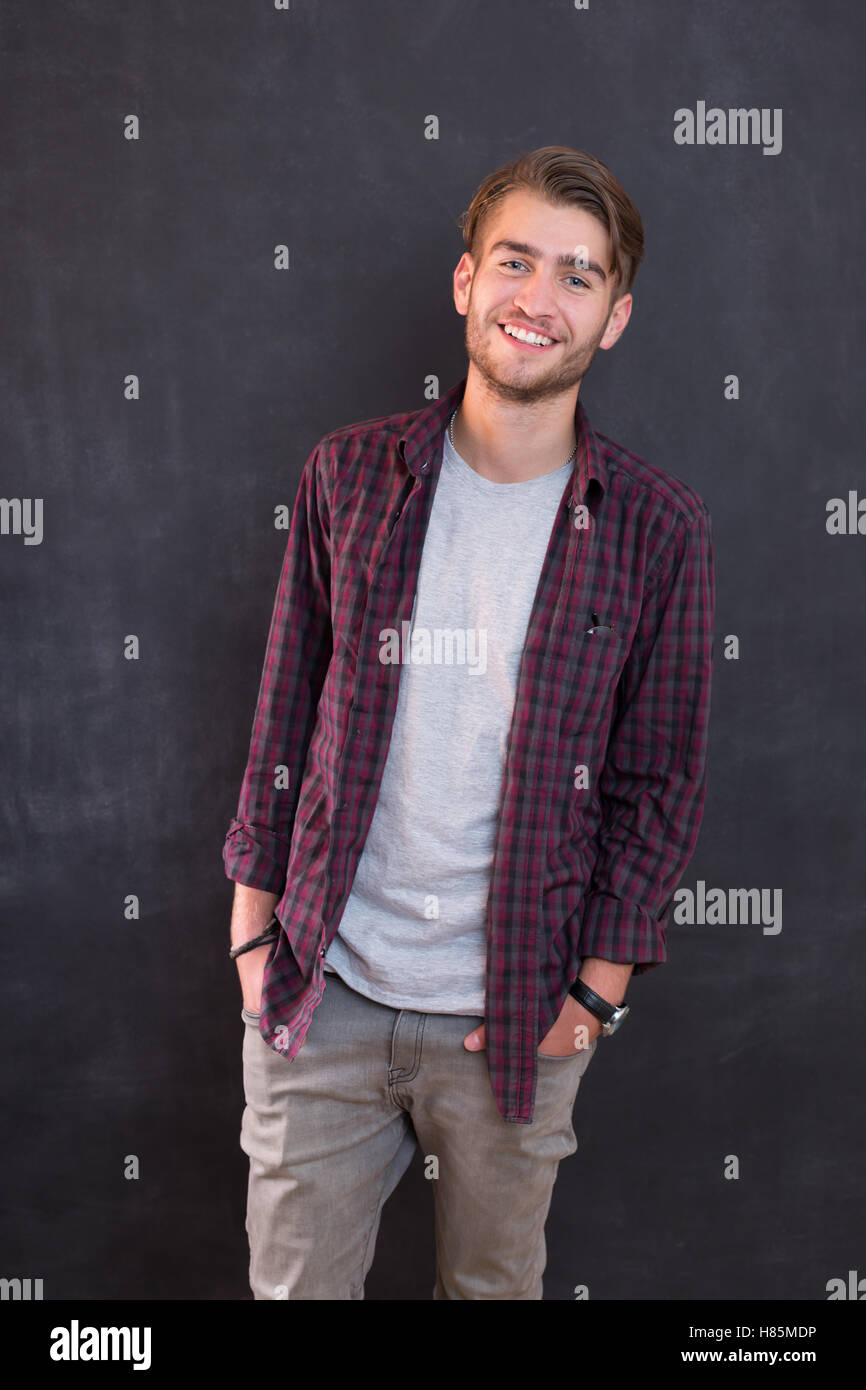 Handsome young student in shirt standing against blackboard Stock Photo ...