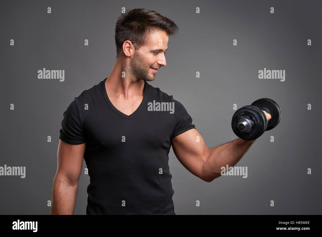 A handsome young man lifting weight and feeling confident Stock Photo ...