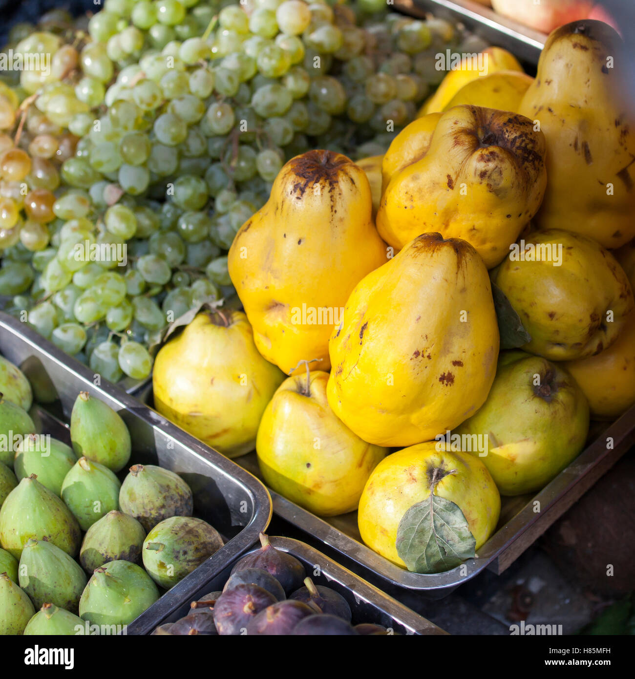 grapes, quince, tangerines, figs in containers for sale in a vegetable ...