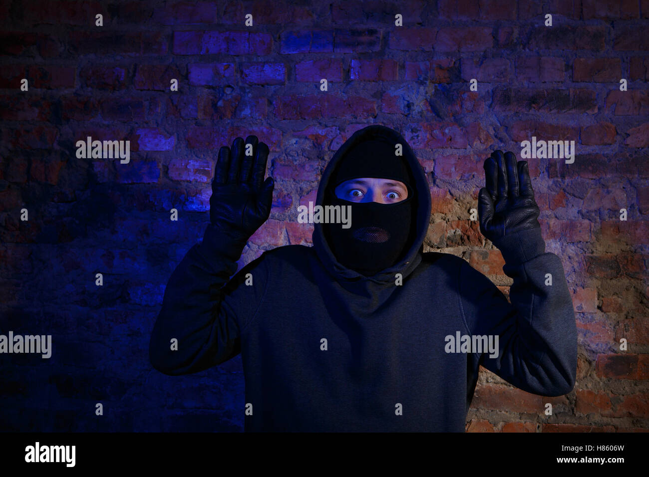Surprised thief with hands up Stock Photo - Alamy
