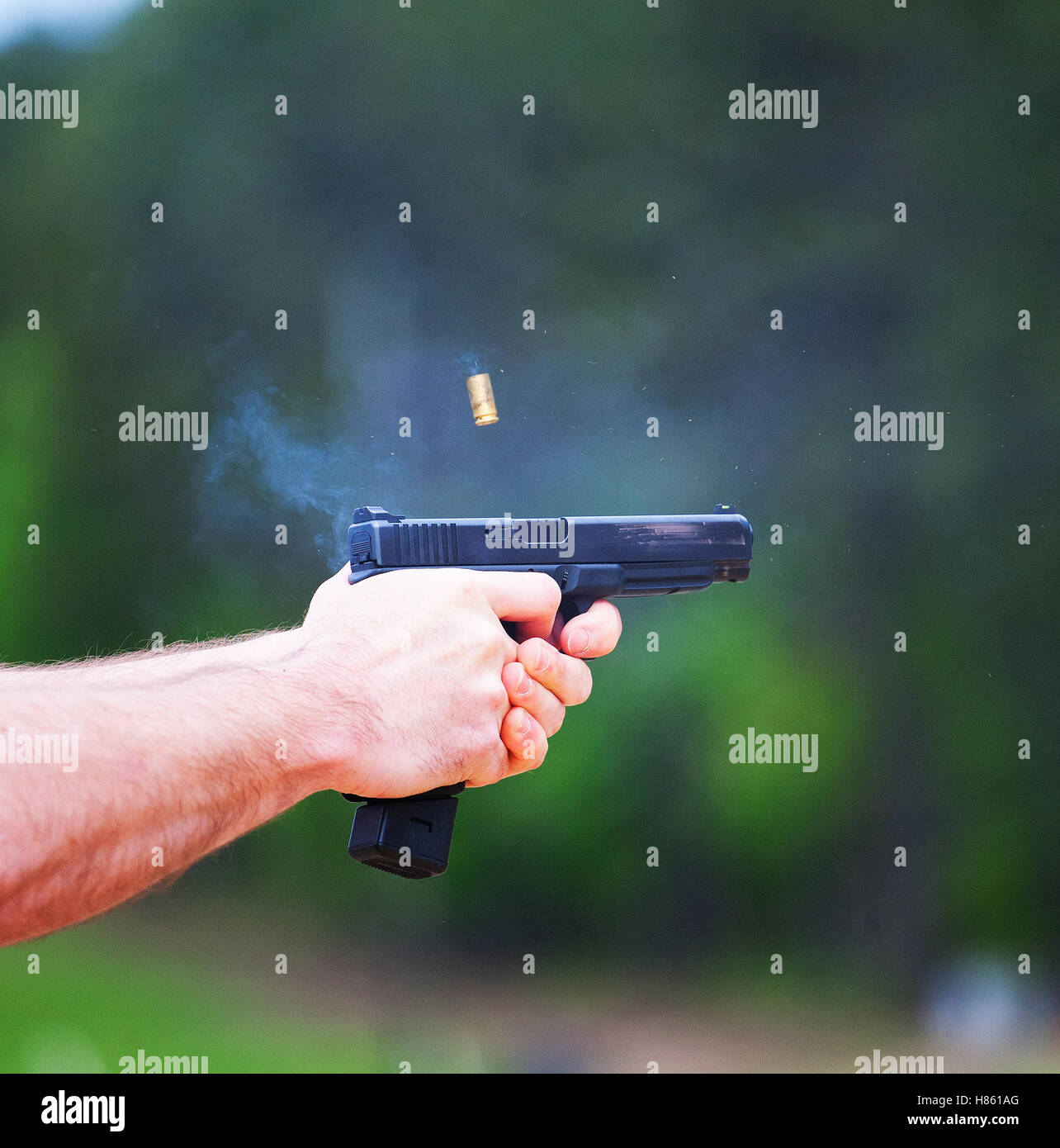 Semi automatic handgun being shot with brass in the air Stock Photo - Alamy