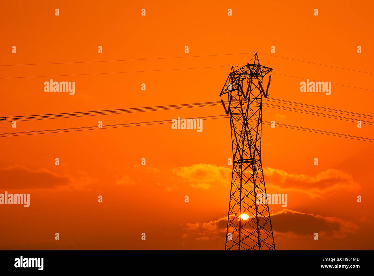 isolated high voltage pylon on orange sky Stock Photo - Alamy