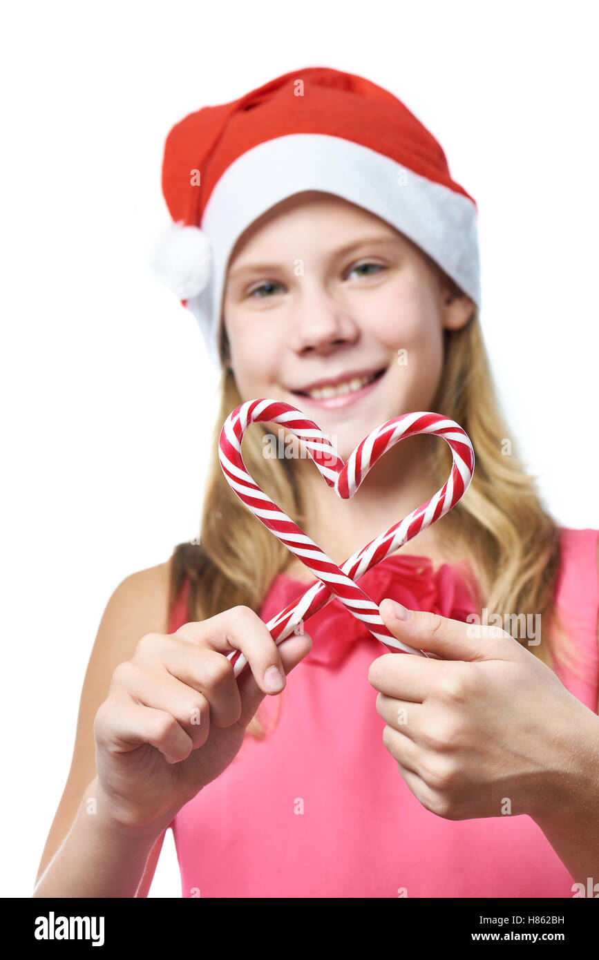 Girl in red cap with christmas candy canes as heart isolated white ...