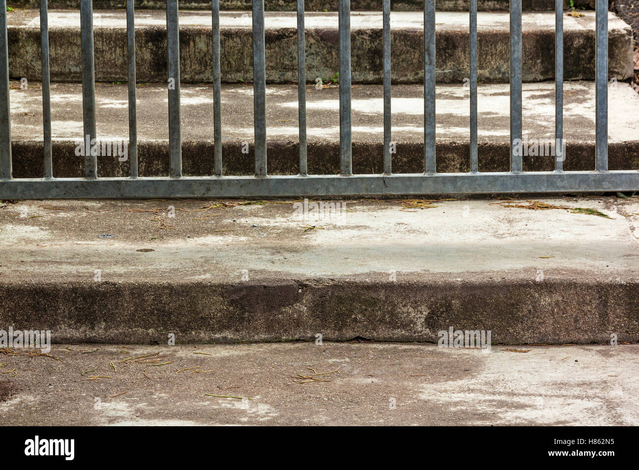 Close up of portion of galvanized metal gate and vintage concrete steps ...