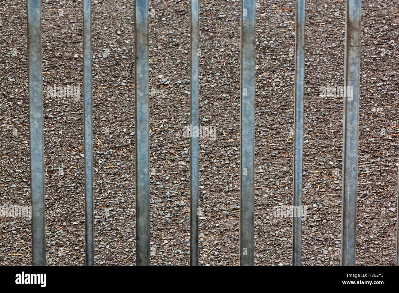 Close up of galvanized metal gate and asphalt tar texture background ...