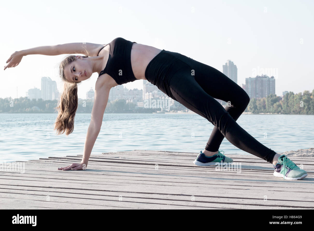 Young pretty slim fitness sporty woman stretches at yoga poses during ...