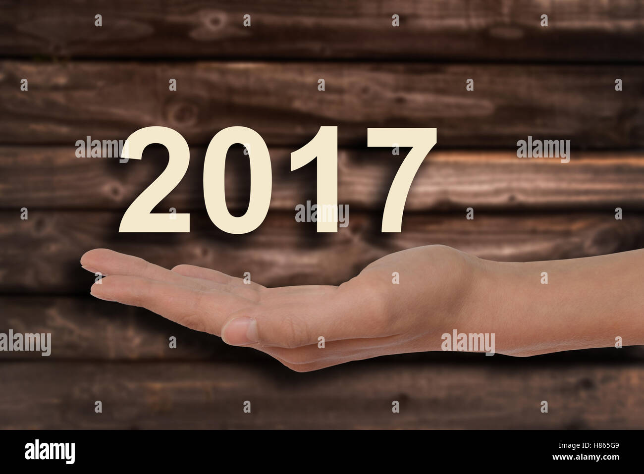 Hand offering 2017 numbers, wood background Stock Photo - Alamy