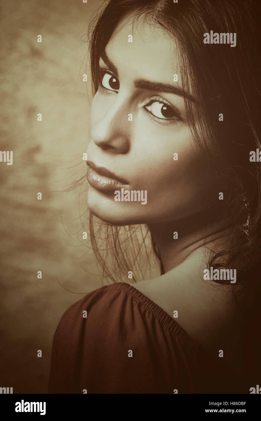 Portrait of a beautiful young woman looking over shoulder Stock Photo ...