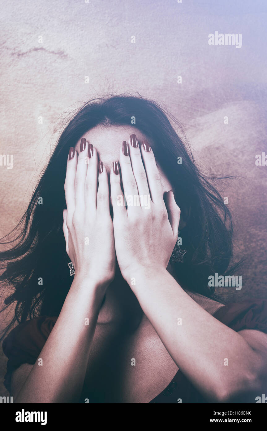 Young woman hiding face with hands Stock Photo - Alamy