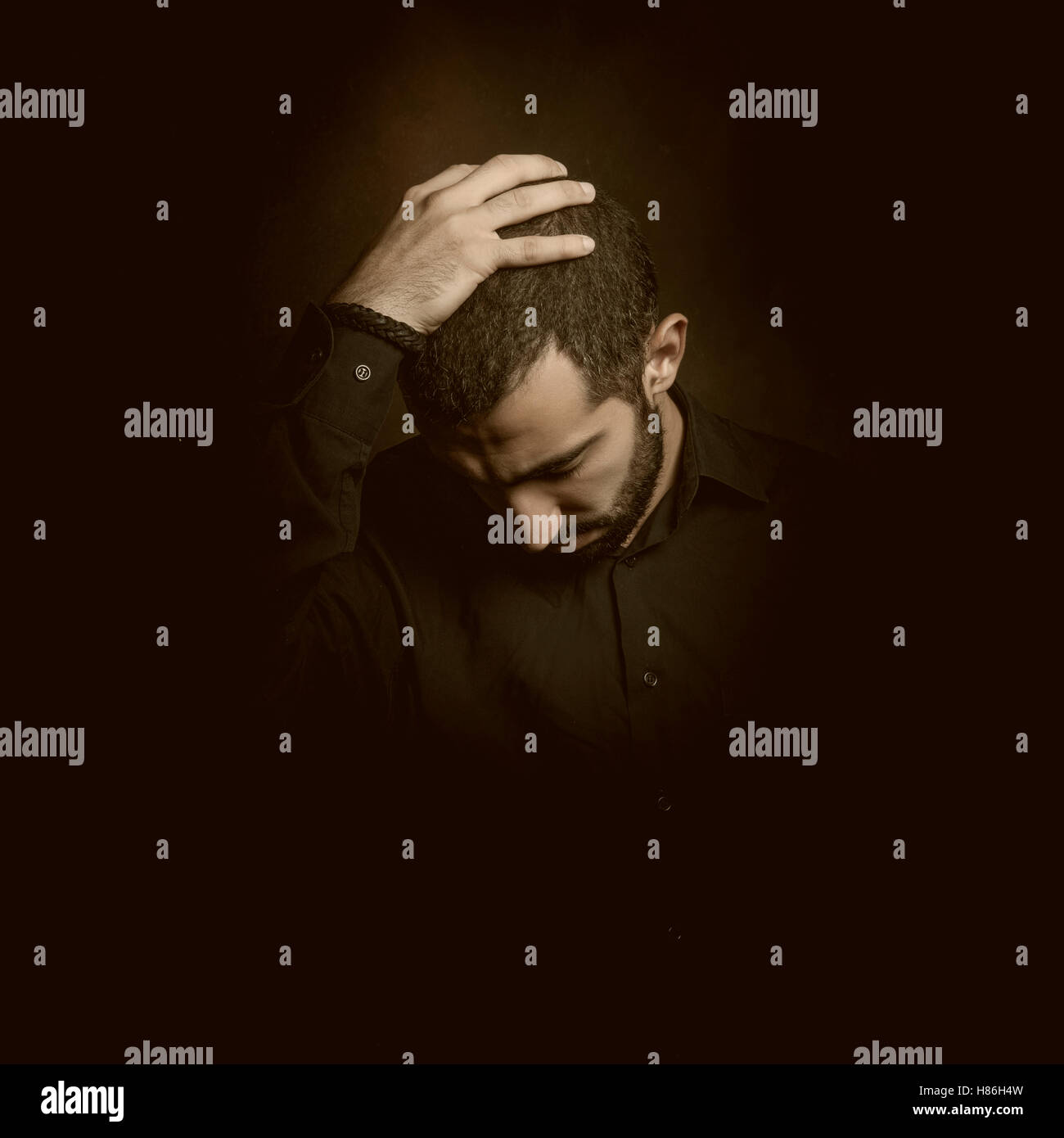 Depressed man hand on head looking down Stock Photo - Alamy