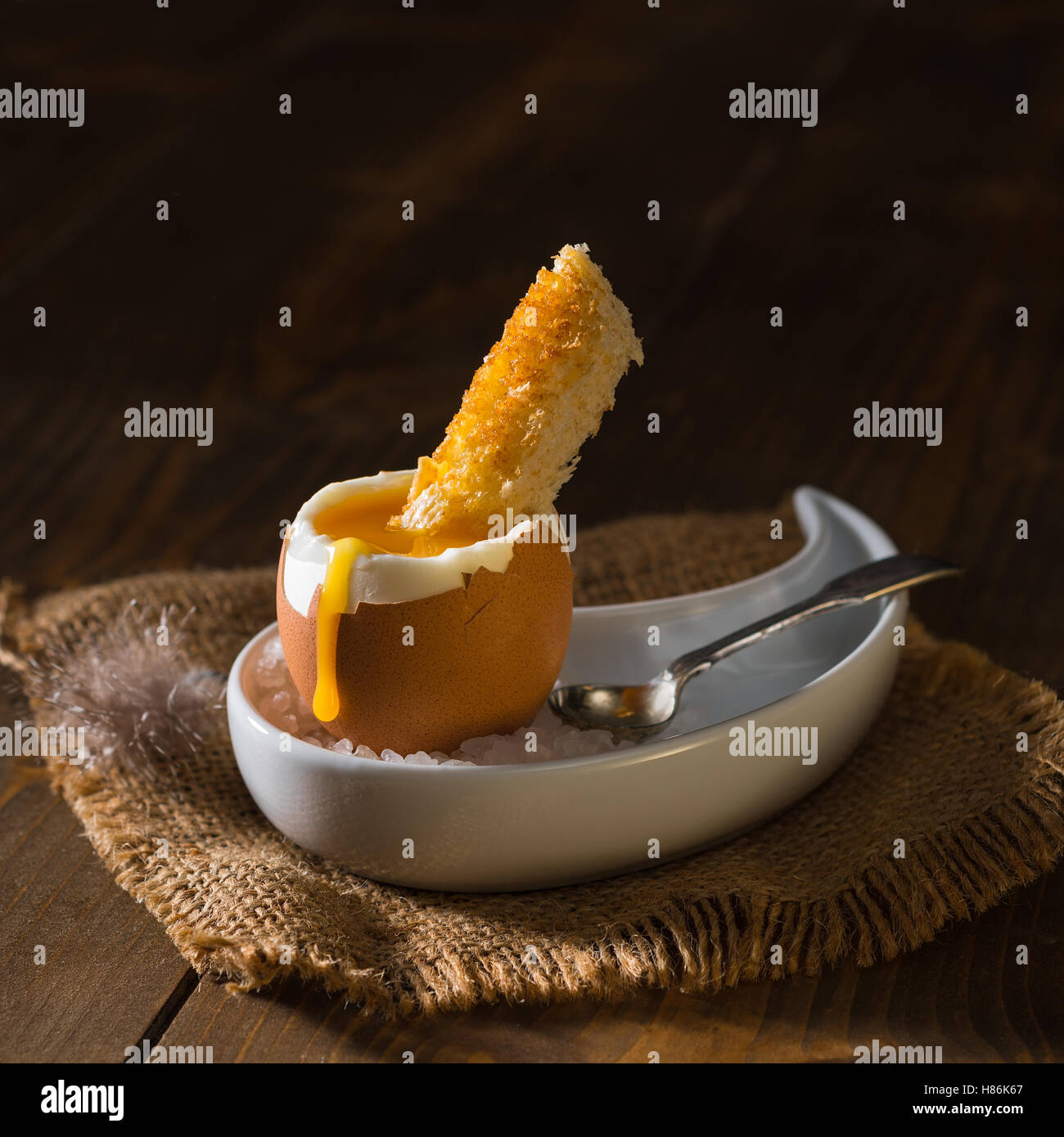 Creatively lit soft boiled egg with bread slice Stock Photo - Alamy