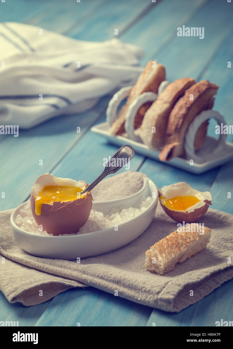 Spoon being dipped into soft boiled egg for breakfast Stock Photo - Alamy