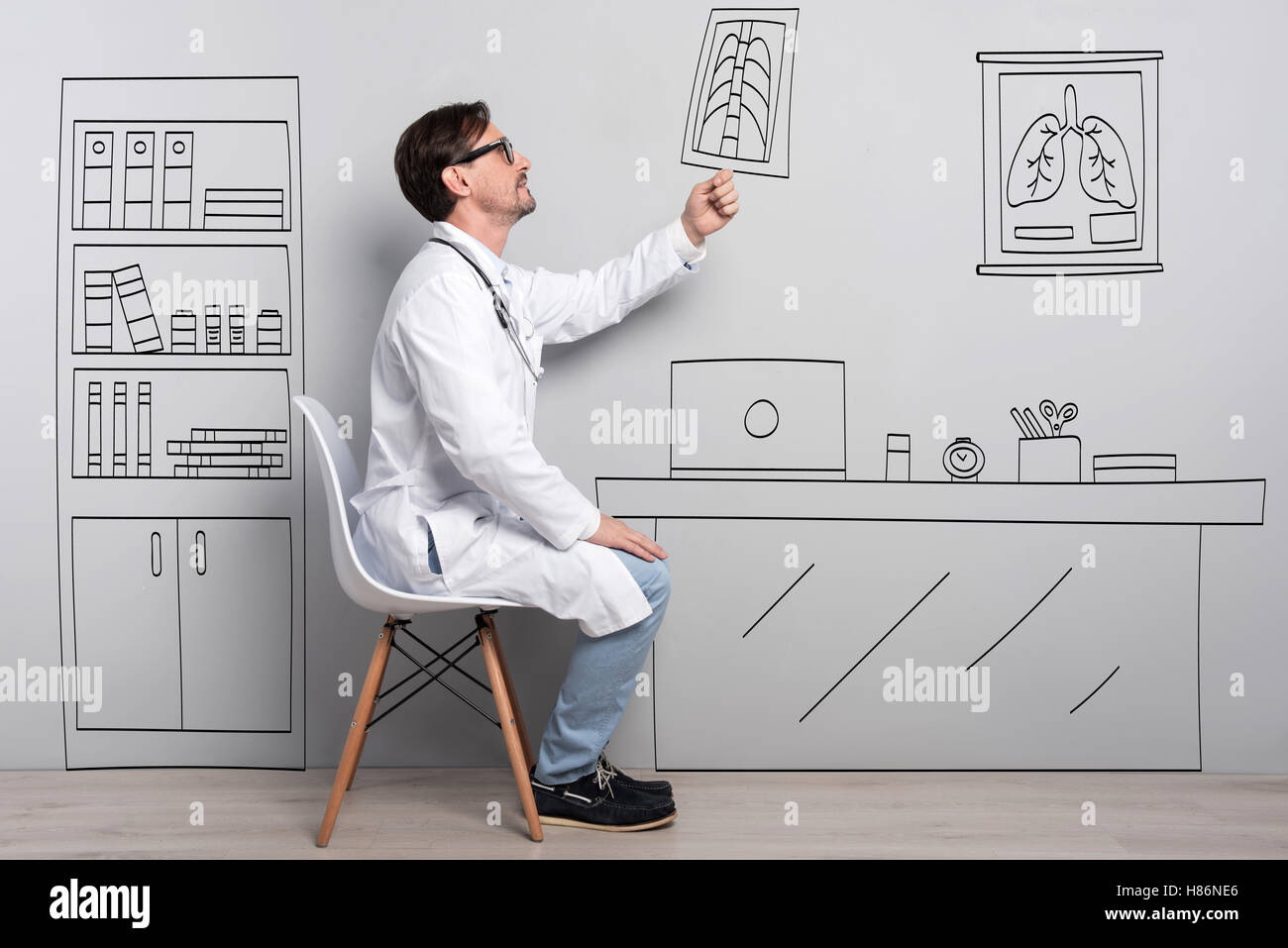 Positive doctor sitting on the chair Stock Photo - Alamy