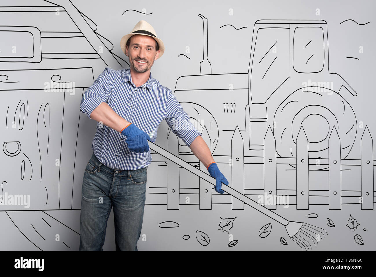 Happy farmer cleaning up in the yard Stock Photo - Alamy