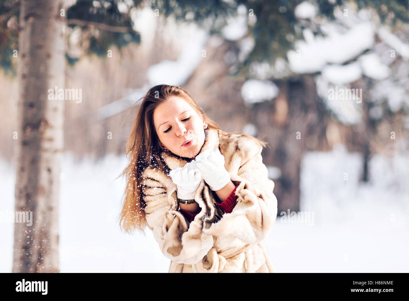 Young beautiful woman blowing snow in winter Stock Photo - Alamy