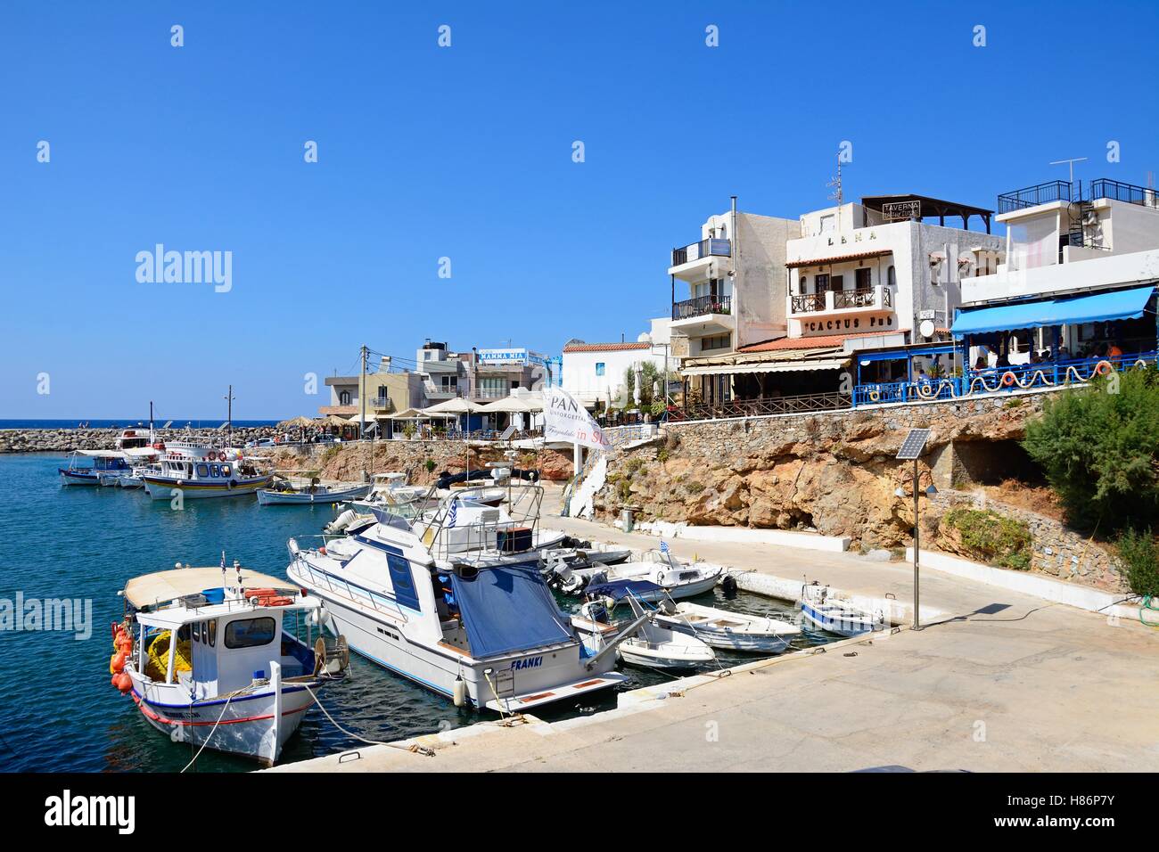 Boats moored in the harbour with waterfront restaurants to the rear ...