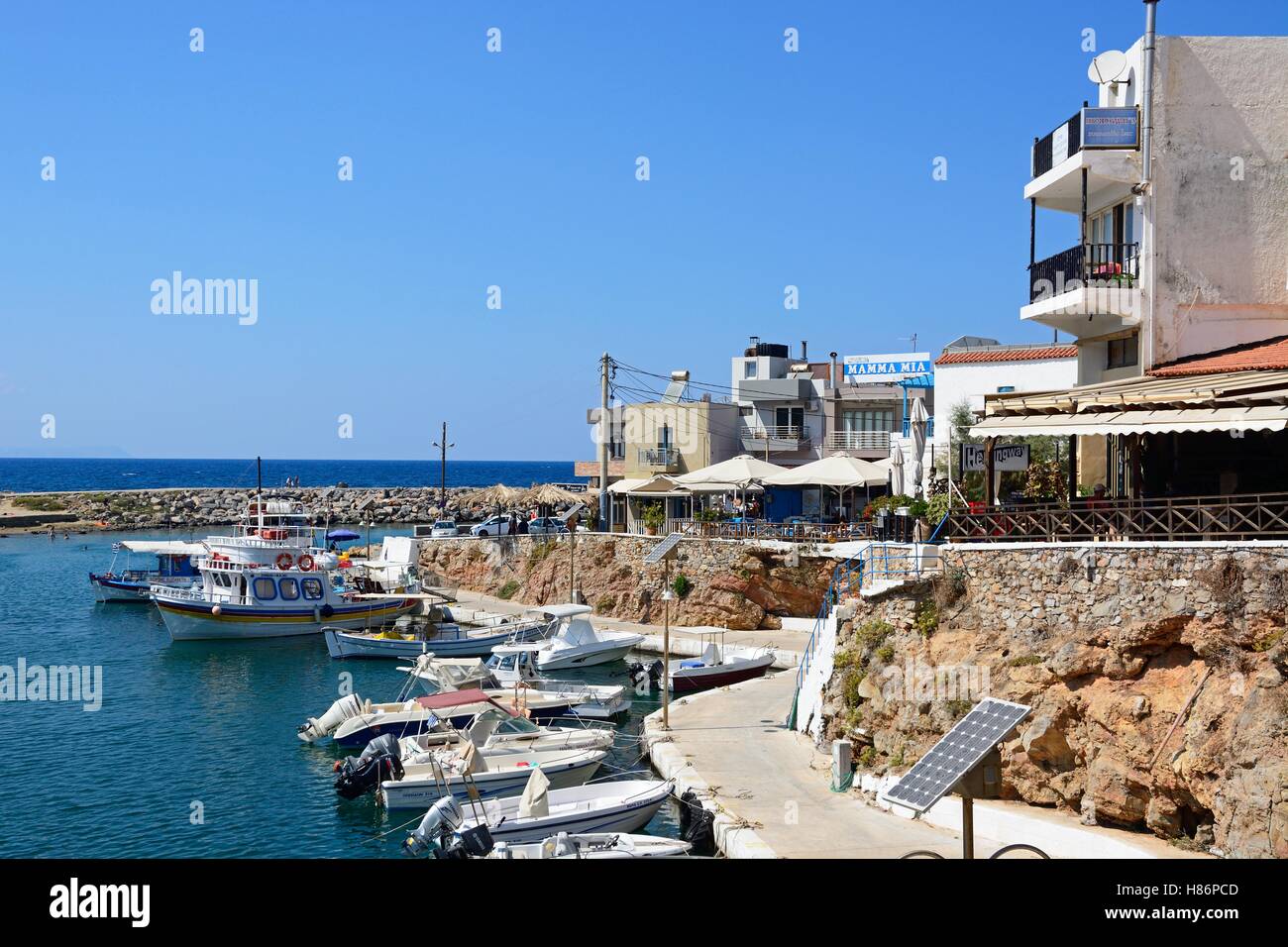 Boats moored in the harbour with waterfront restaurants to the right ...