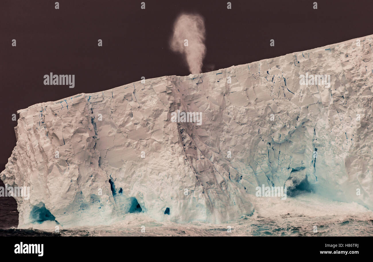Iceberg with water being blown through crack, Antarctica Stock Photo ...