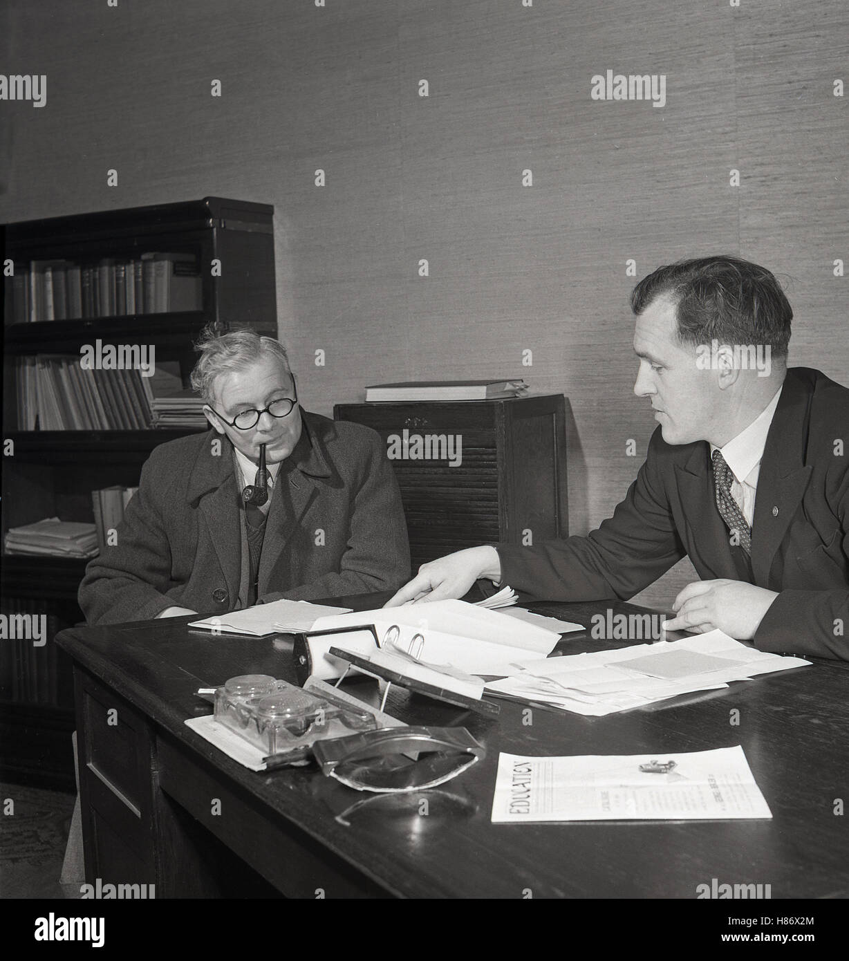 1950s, historical, office meeting. Gentleman wearing overcoat and ...
