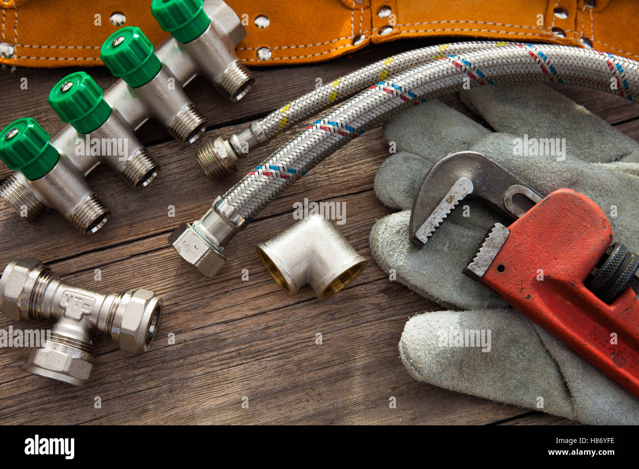 Set of plumbing and tools on the table. Fitting, suede gloves and ...