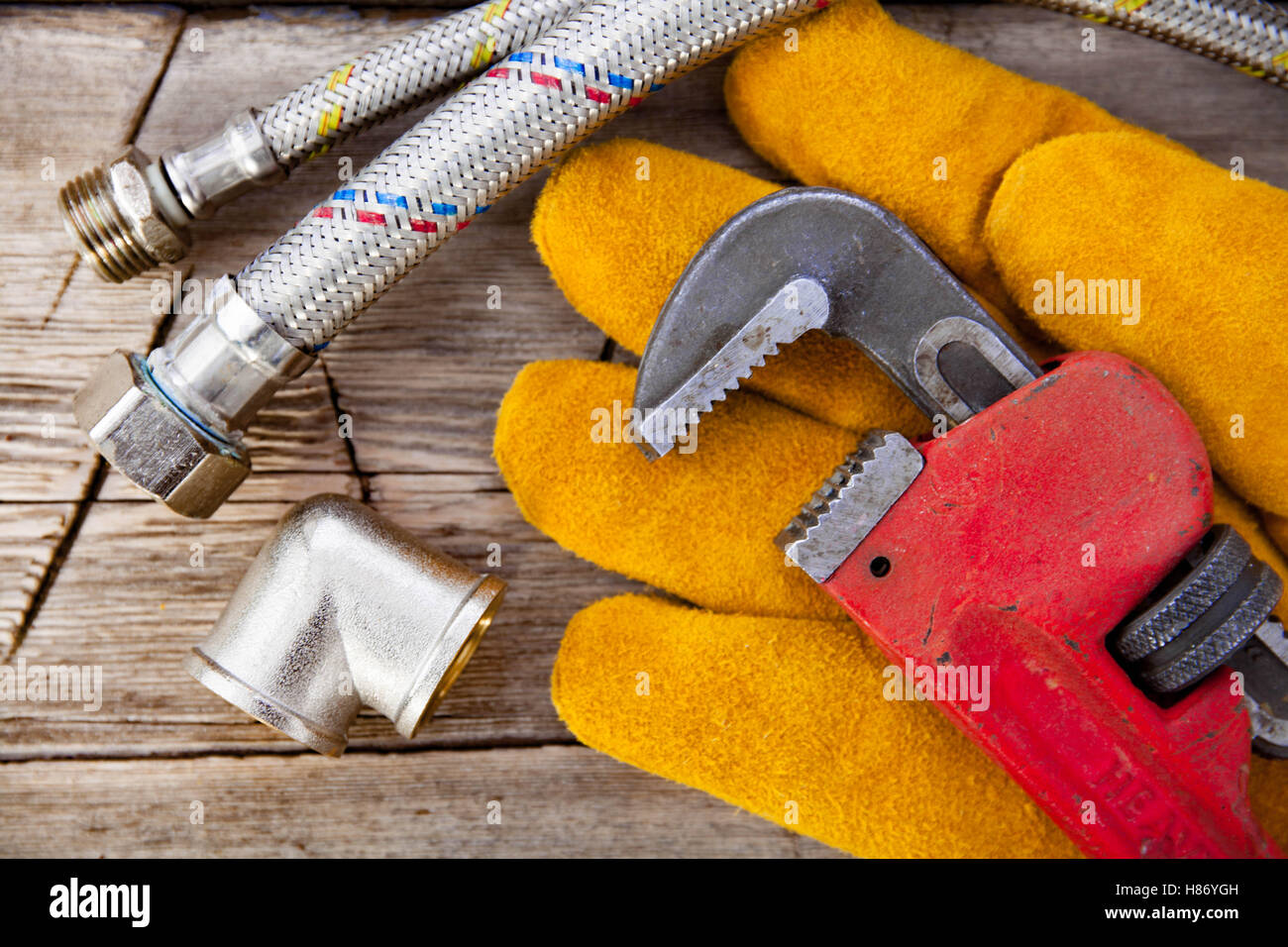 Set of plumbing and tools on the table. Fitting, suede gloves and ...