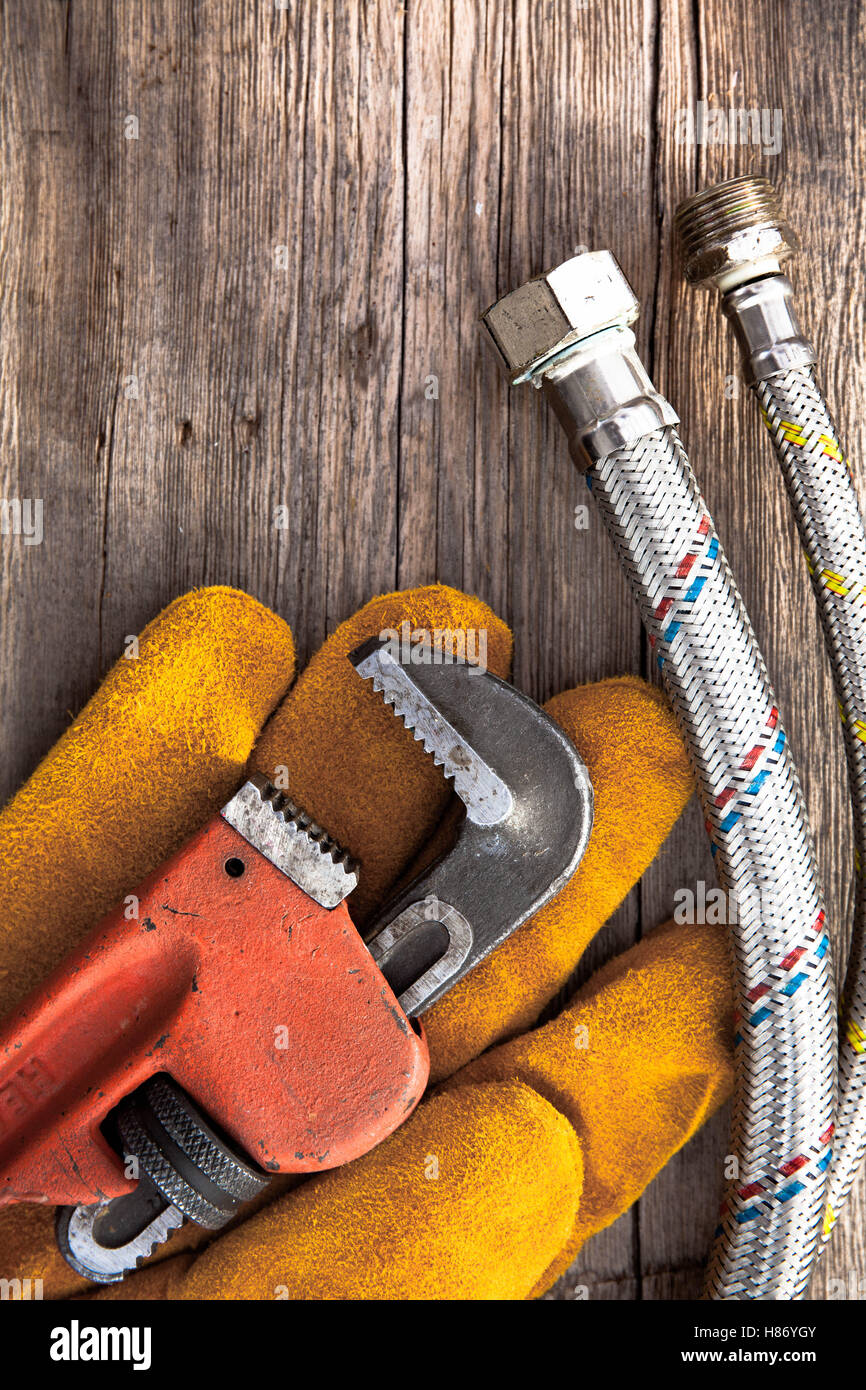 Set of plumbing and tools on the table. Fitting, suede gloves and ...
