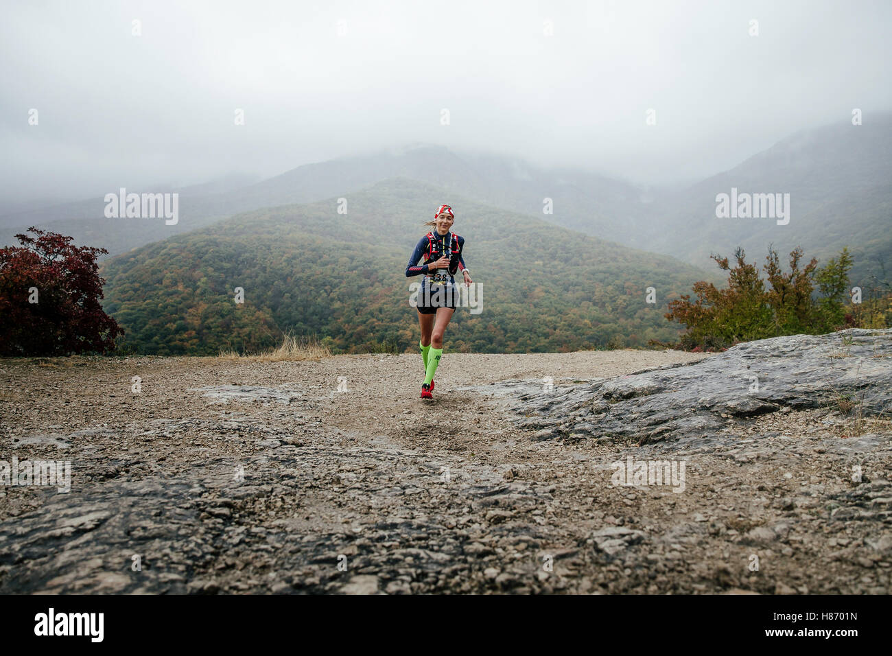 young girl runner running in rain with a smile on face during Crimea ...