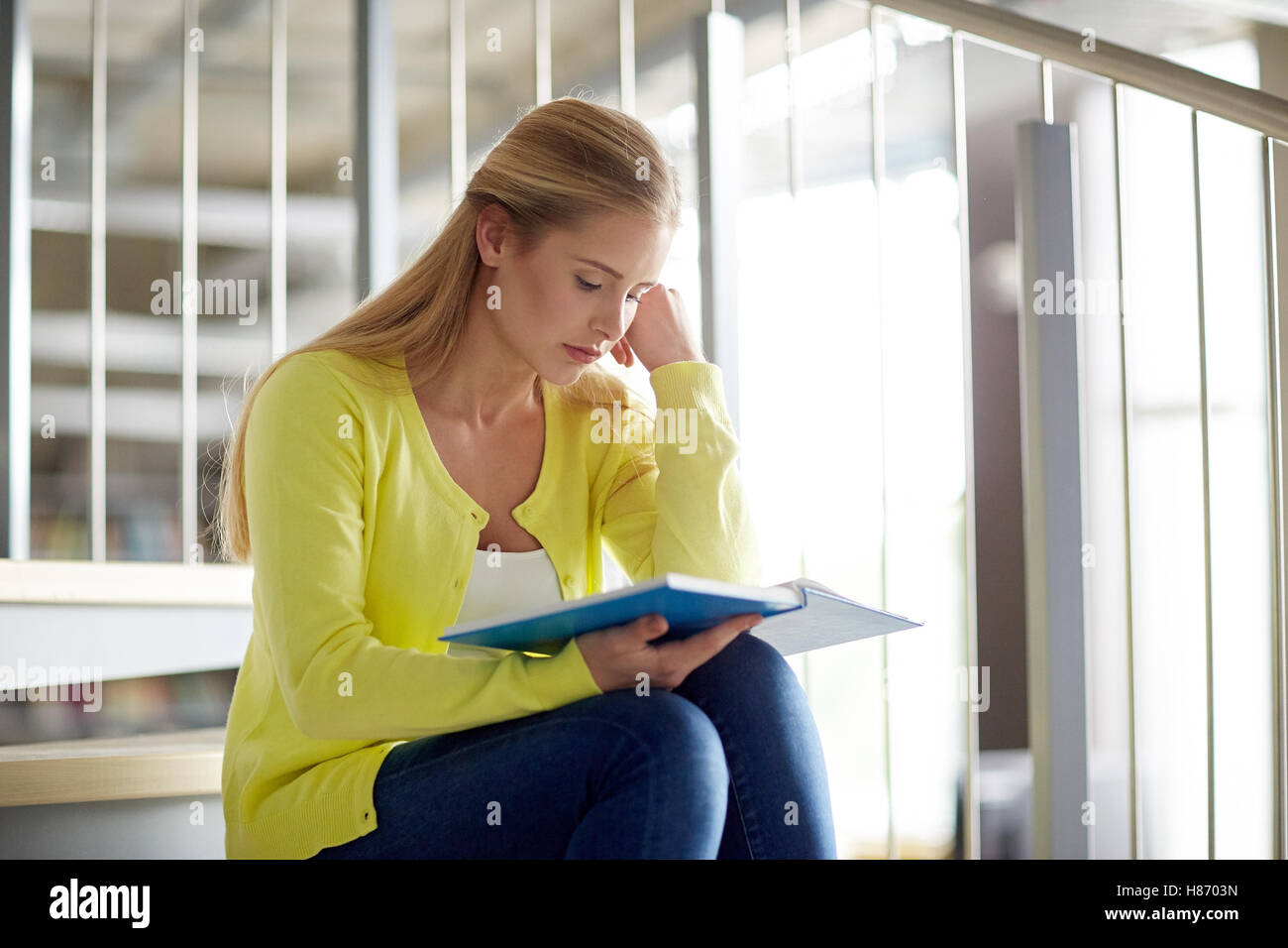high school student girl reading book on stairs Stock Photo - Alamy