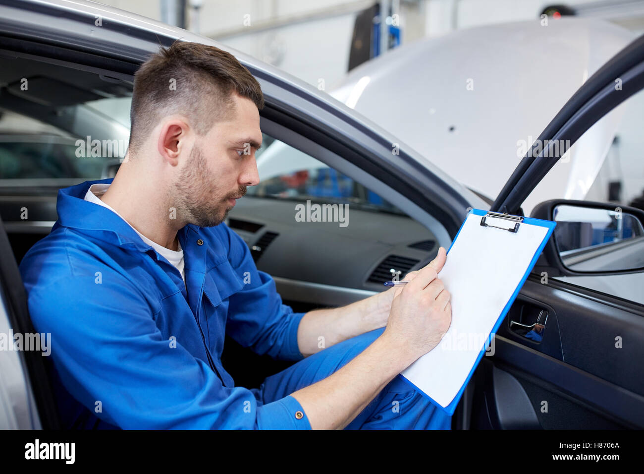auto mechanic man with clipboard at car workshop Stock Photo - Alamy