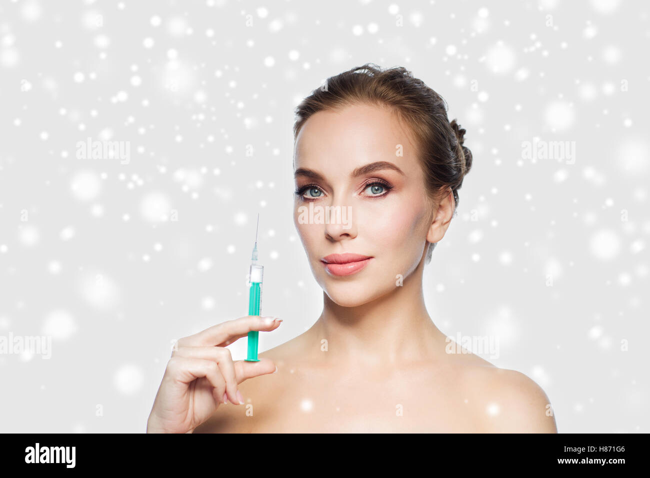 woman holding syringe with injection over snow Stock Photo - Alamy