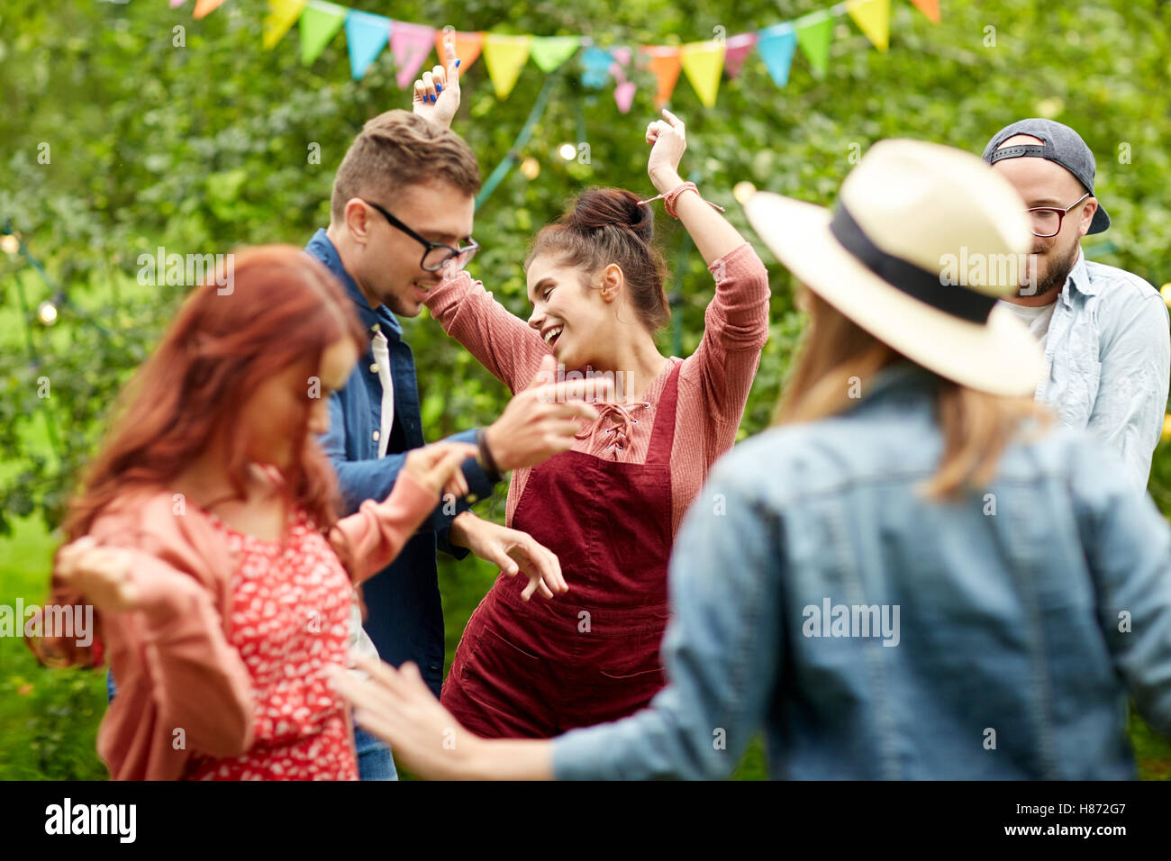 happy friends dancing at summer party in garden Stock Photo - Alamy