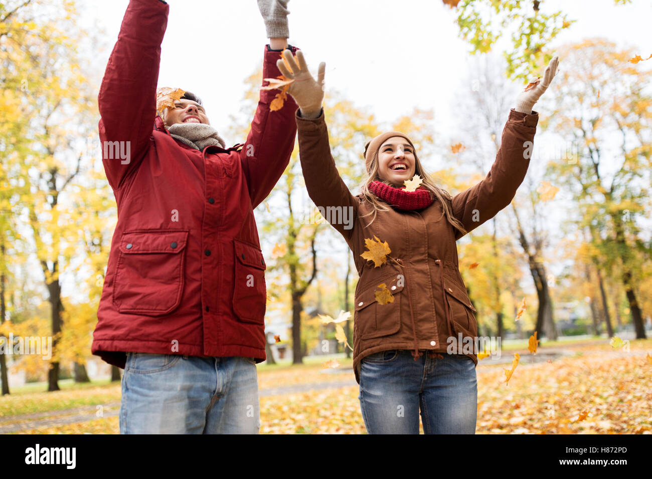 happy young couple throwing autumn leaves in park Stock Photo - Alamy