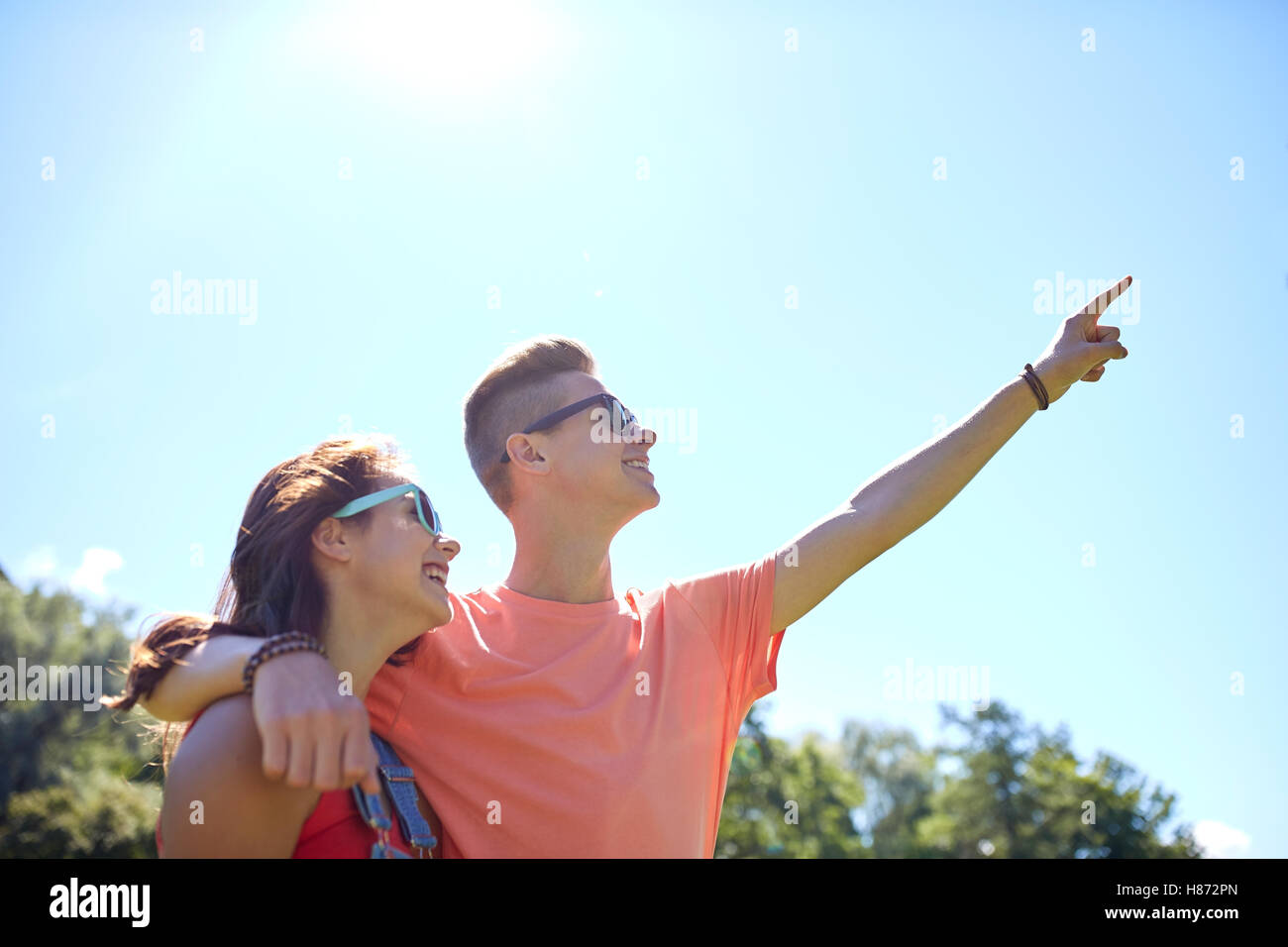 happy couple pointing finger at summer park Stock Photo - Alamy