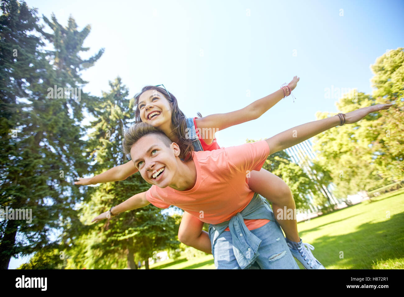 happy teenage couple having fun at summer park Stock Photo - Alamy