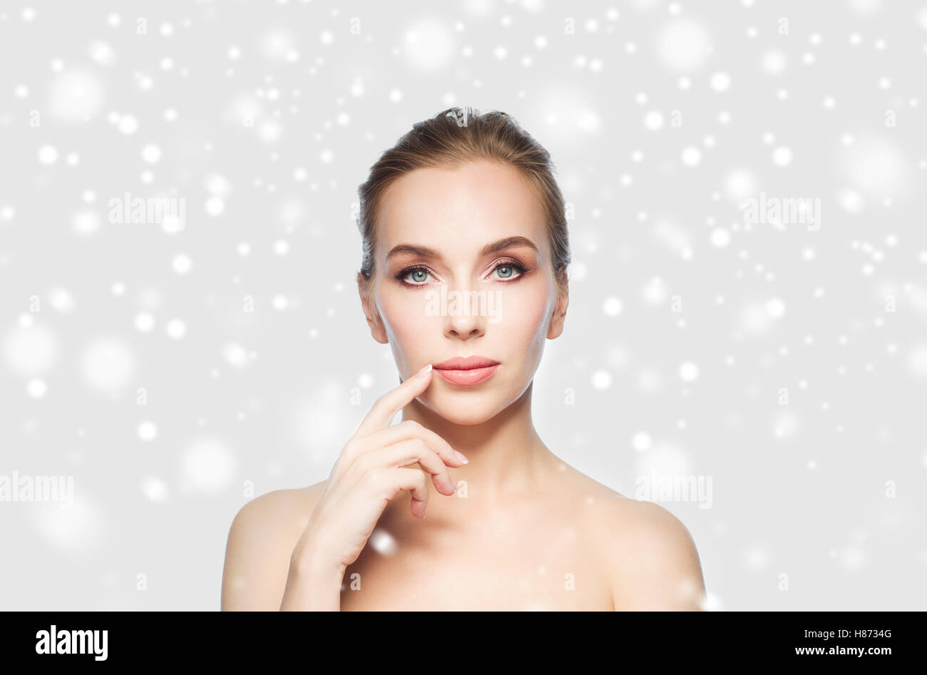 beautiful young woman showing her lips over snow Stock Photo - Alamy
