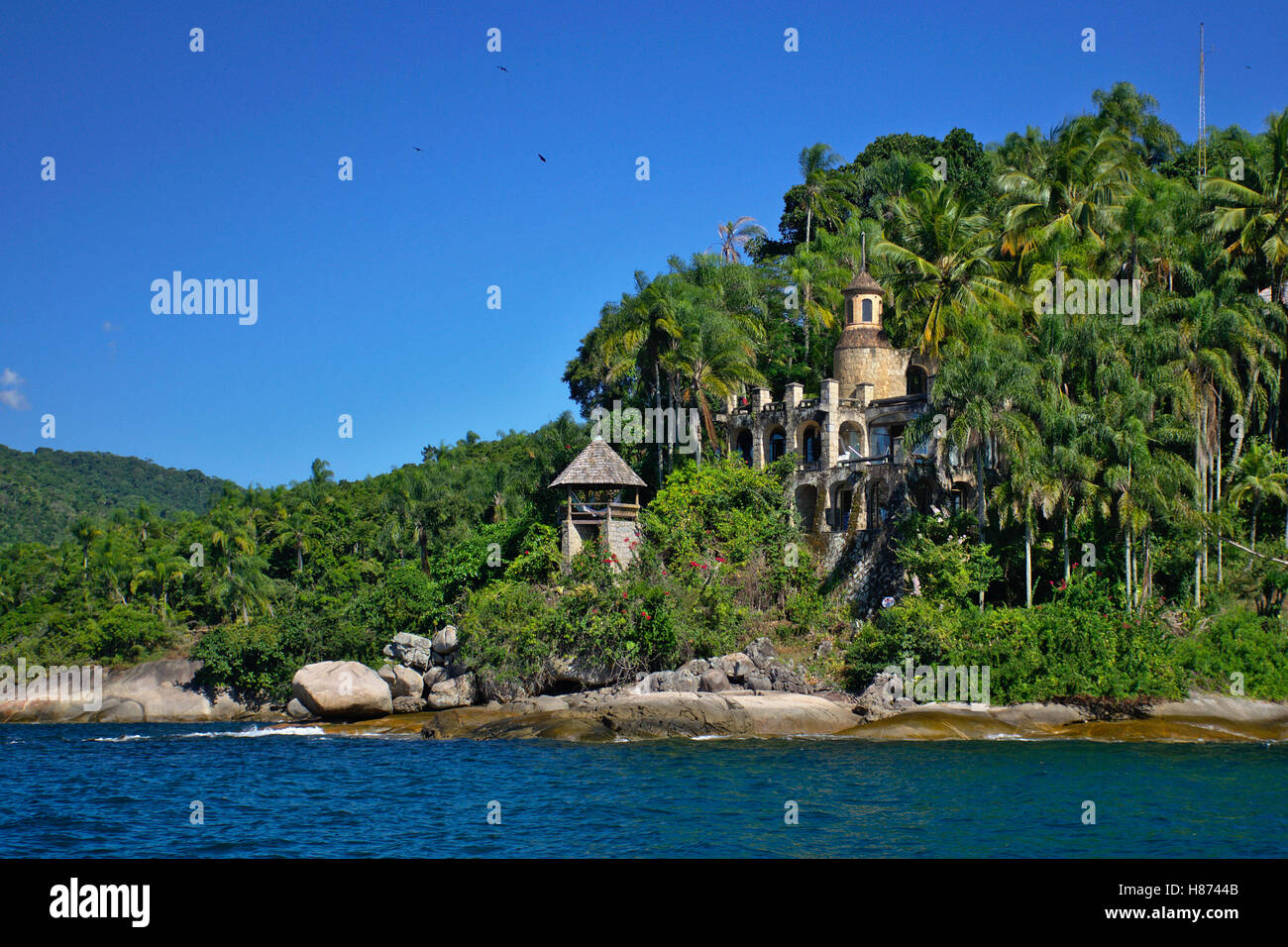 Small castle in a tropical island almost covered by greenery Stock ...