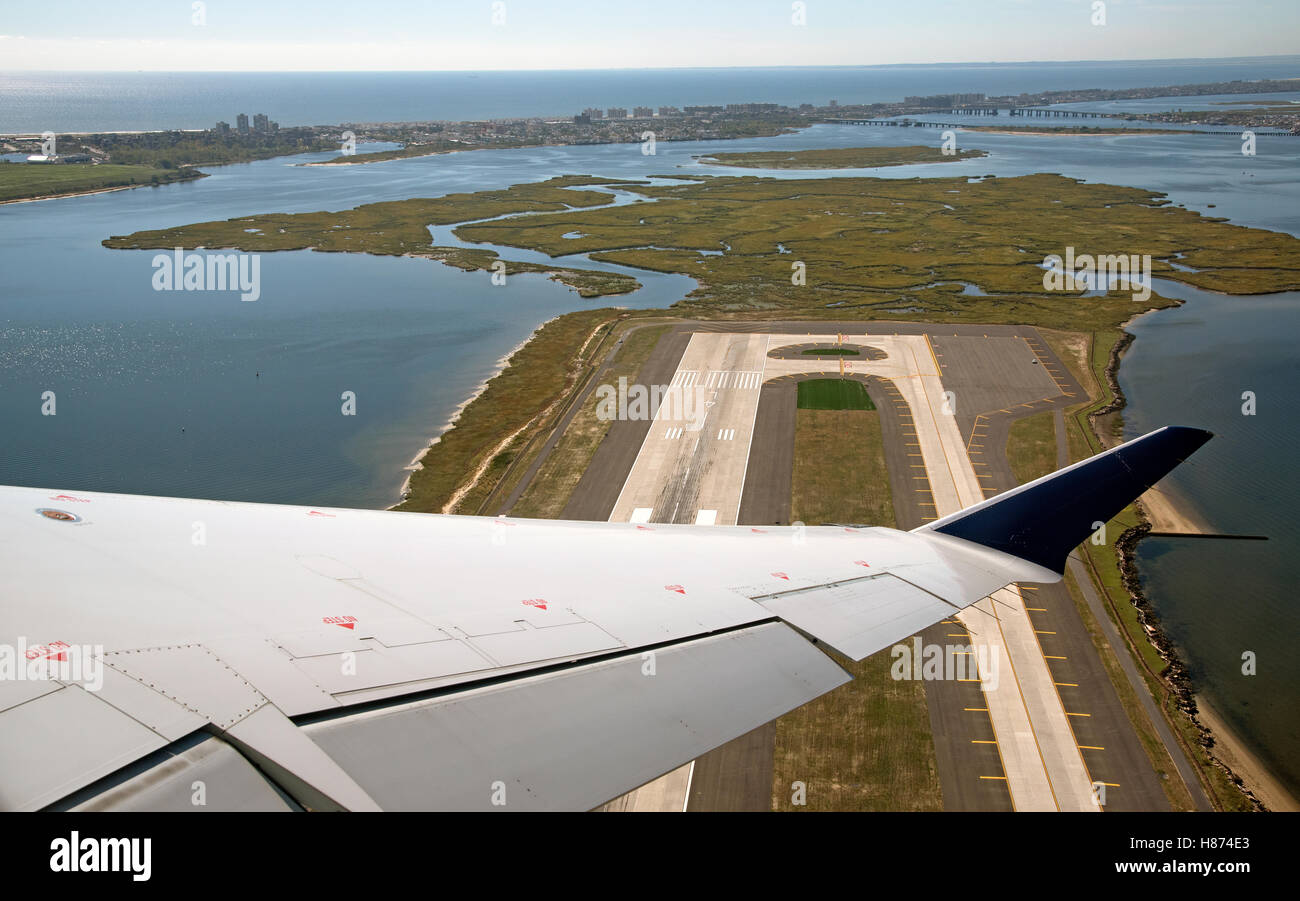 View of aircraft wing passing over end of a runway after taking off ...